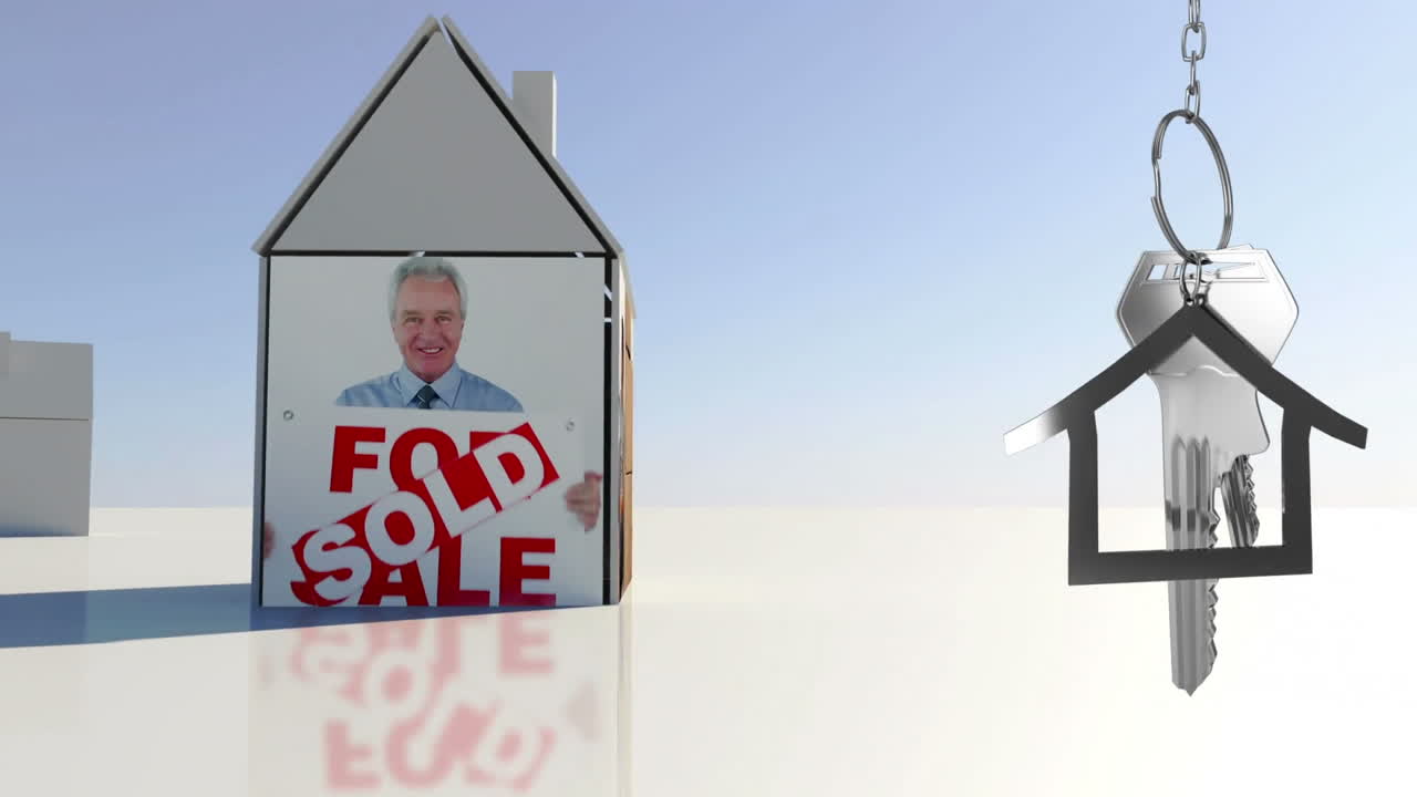 House keys and key fob hanging over 3d house models in the background ...