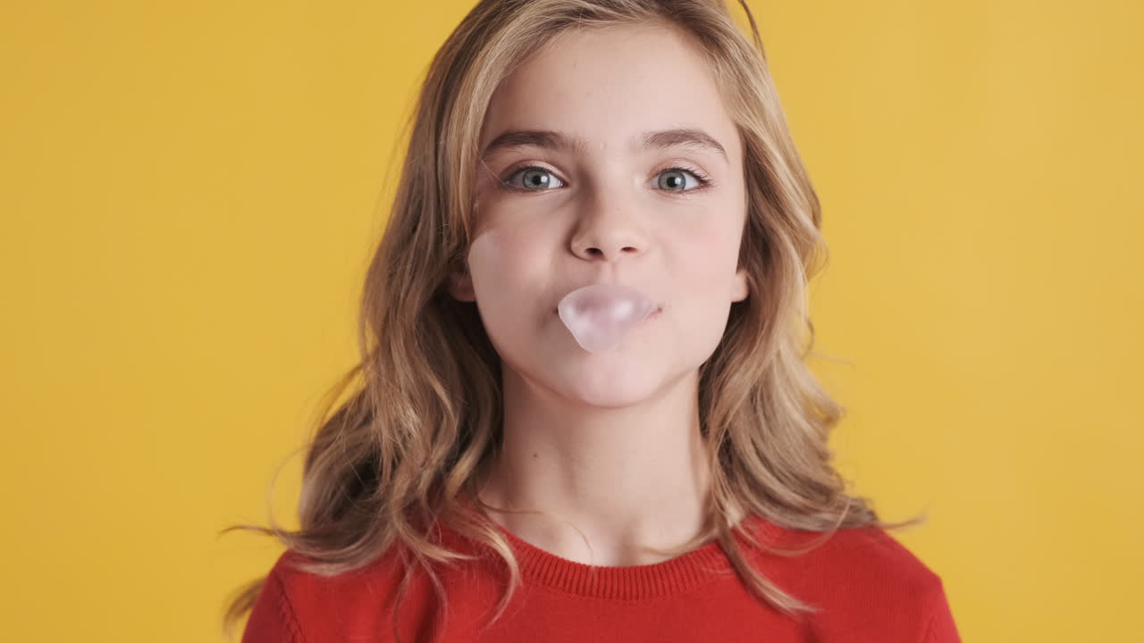無料 ストック動画 ティーンエイジャーの白人の女の子がガムをんでバブルを吹いています