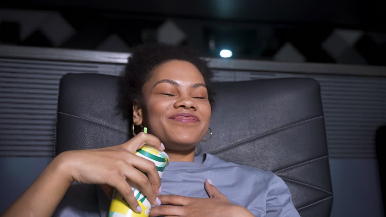 Free stock video - Young african american woman sitting in a vip cinema
