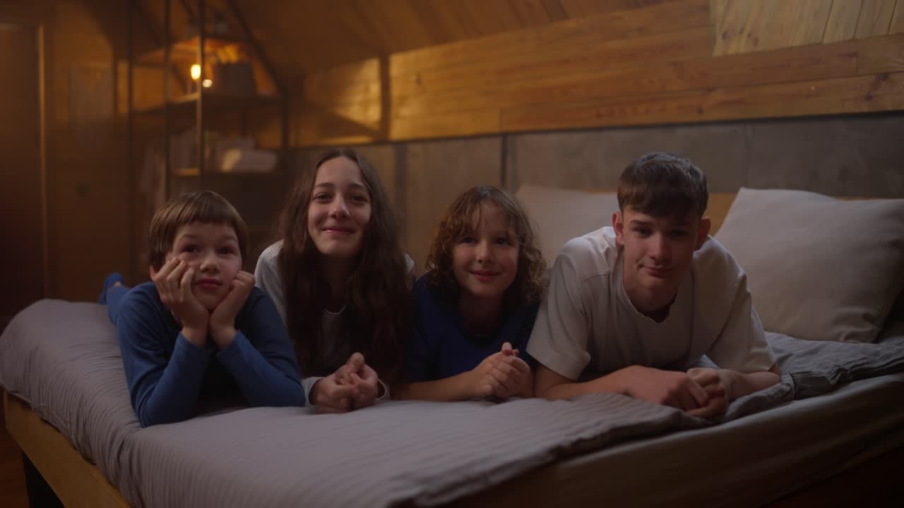 Four siblings lying on a bed in an attic bedroom | Premium Stock Video ...