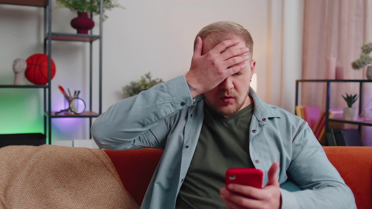 Premium stock video - Sad adult man use mobile smartphone loses ...