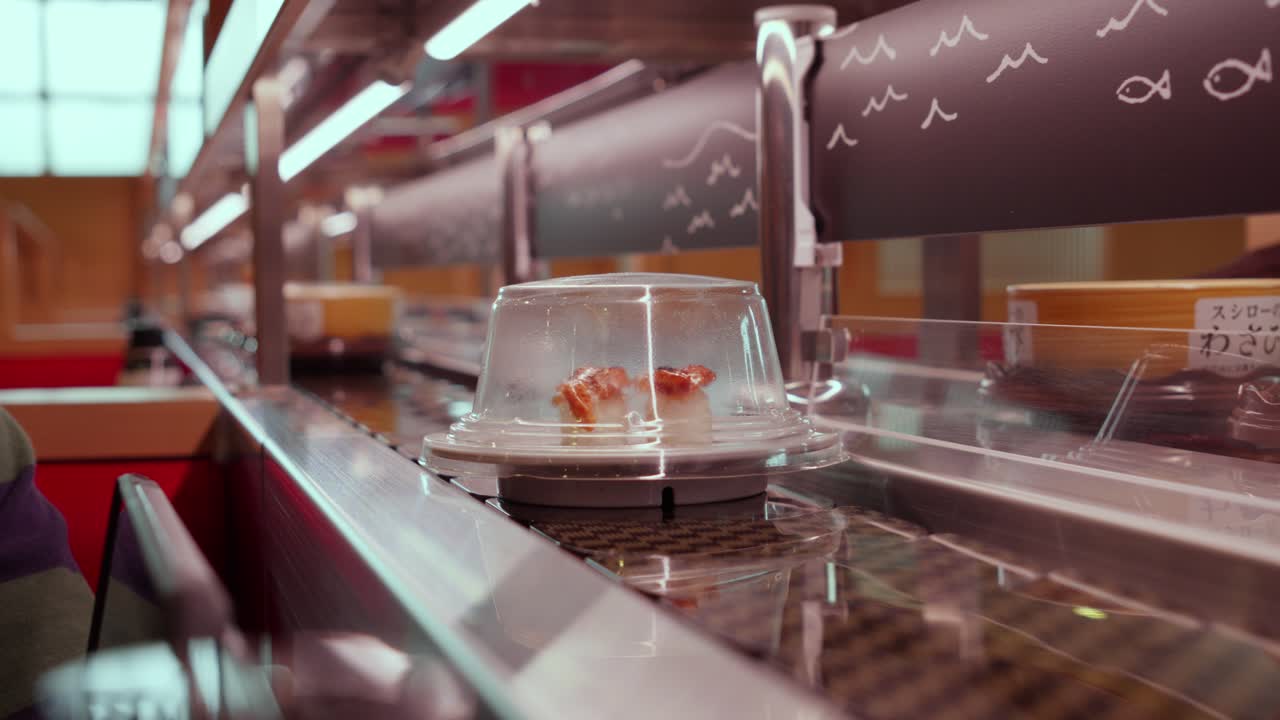 Premium stock video - Sushi plates moving on a conveyor belt in a ...