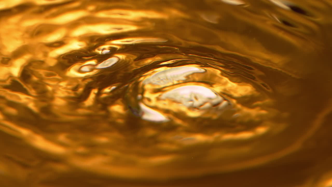 Premium stock video - Boiling liquid gold with ice cubes-1