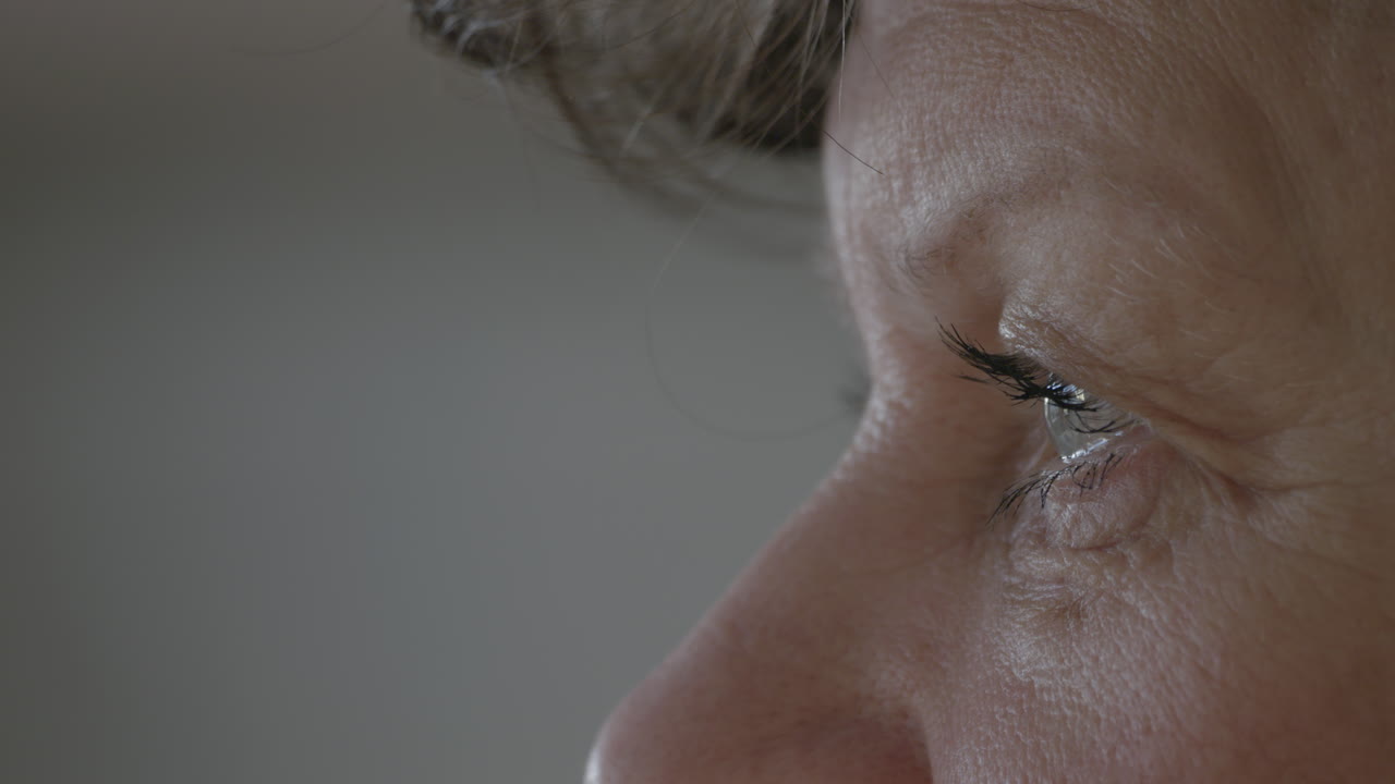 Premium stock video - Senior woman staring into distance, extreme close ...