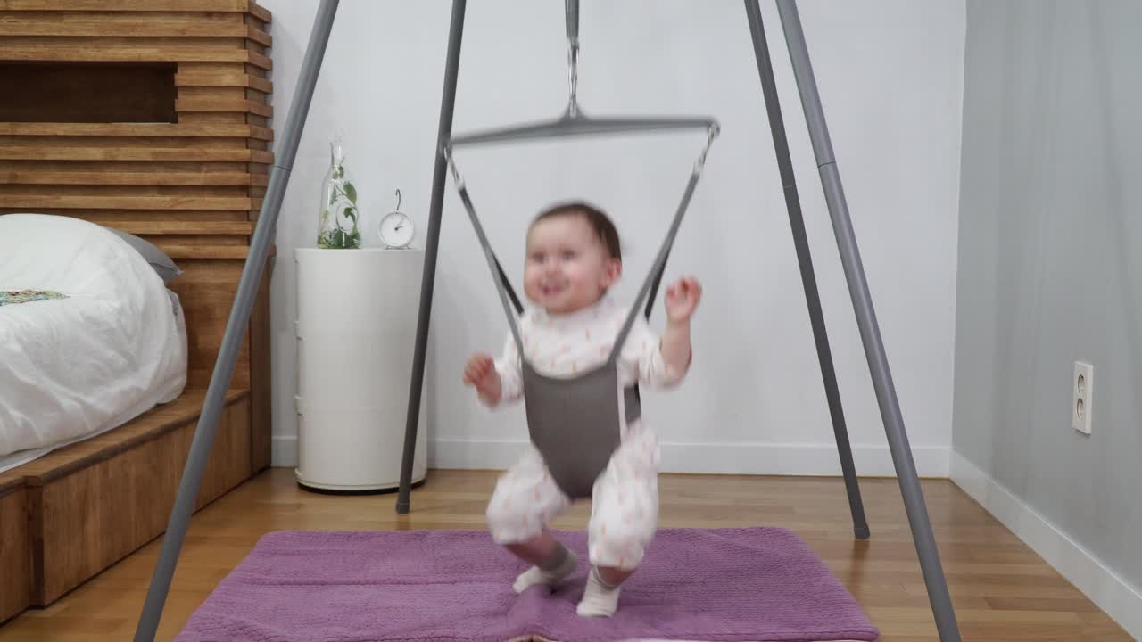 Premium stock video - Excited little baby jumping in bouncer with lots ...