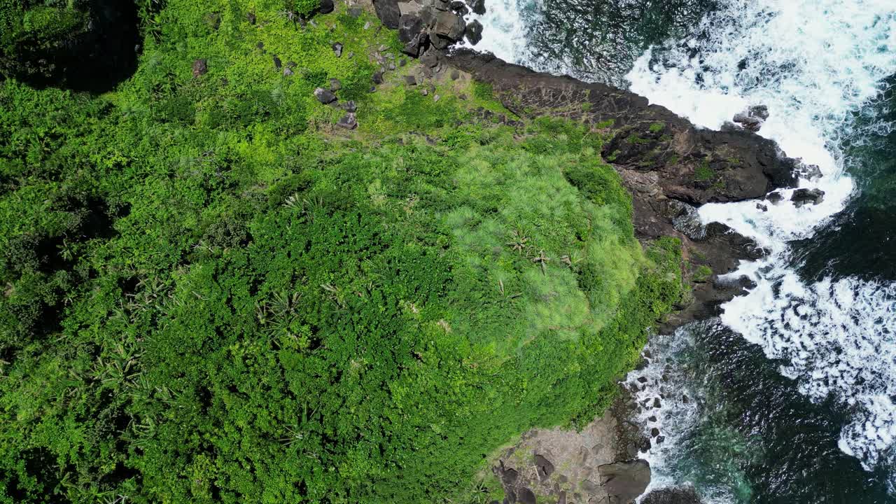 Overhead view breaking waves on rugged shoreline in tropical beach of ...