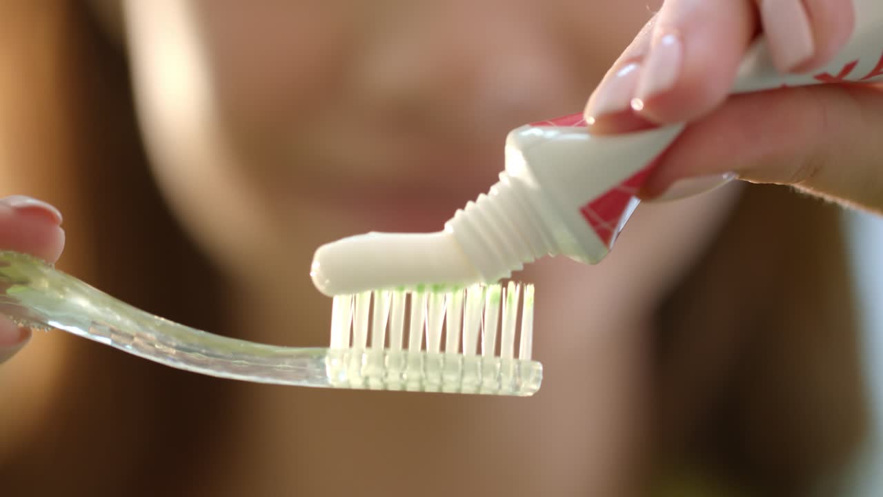 Morning teeth brushing. close up woman hands squeezing toothpaste on ...