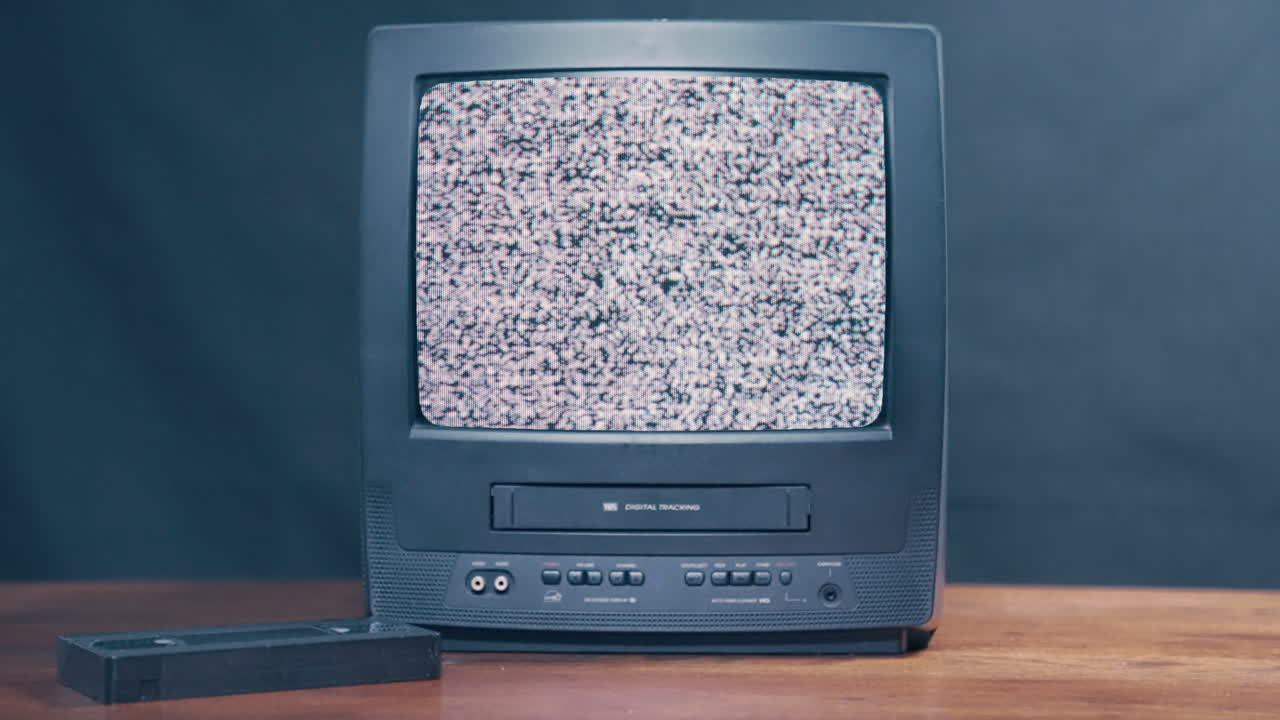 Tabletop television with static playing on the screen, retro technology ...
