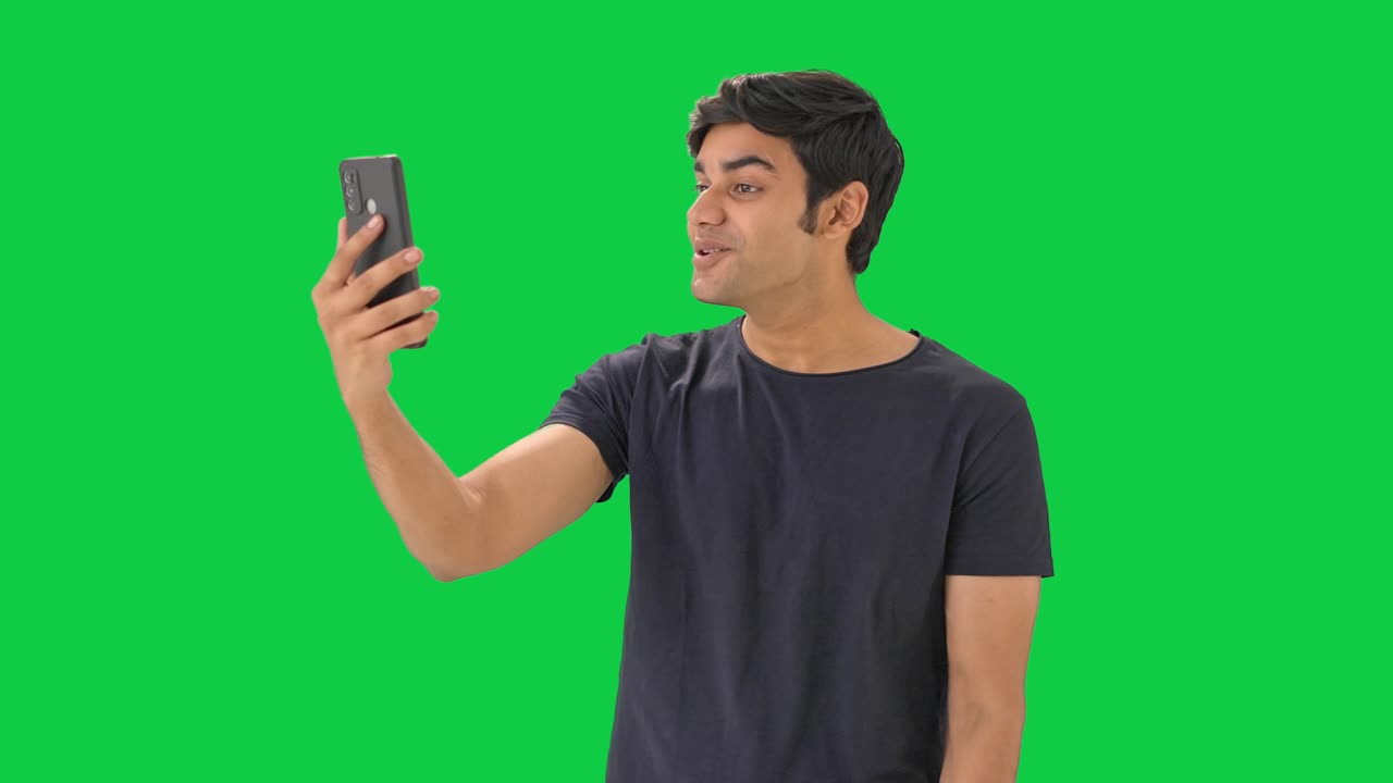 Premium stock video - Happy indian boy talking on video call green screen