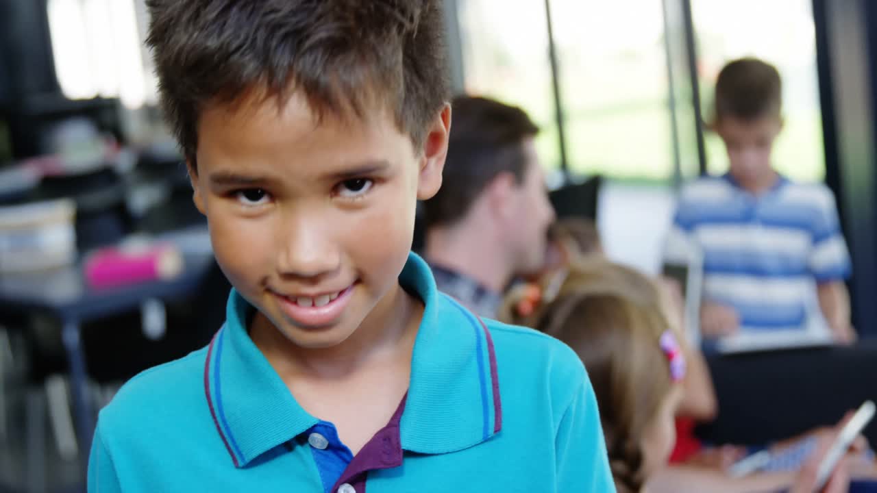 Premium stock video - Portrait of happy schoolboy smiling in classroom
