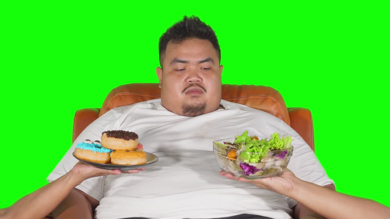 Confused fat man choosing donuts or salad | Premium Stock Video Footage