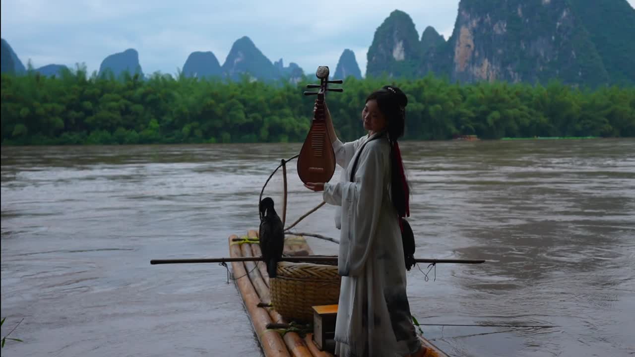 Traditional Chinese woman on a bamboo raft with Pipa and cormorant on a ...