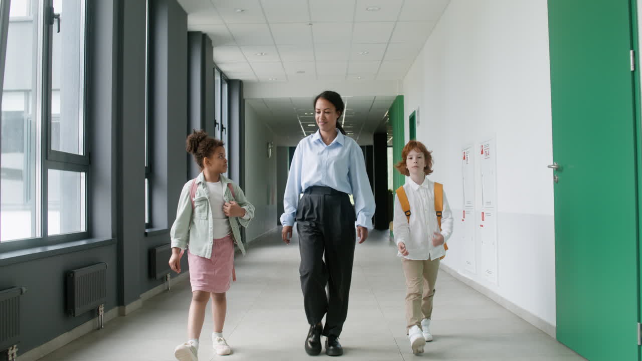 Free stock video - Teacher and pupils walking through the corridor.