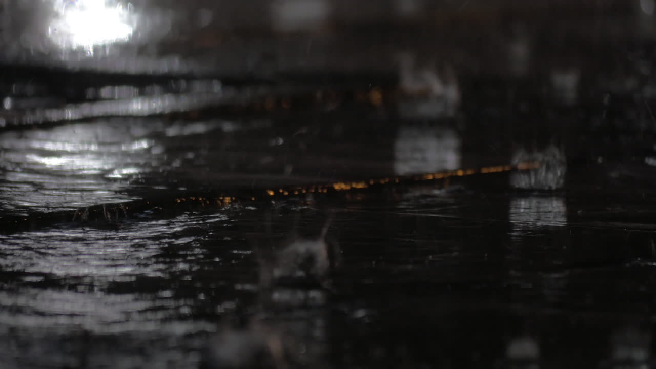 Rain and puddles on sidewalk at night | Premium Stock Video Footage