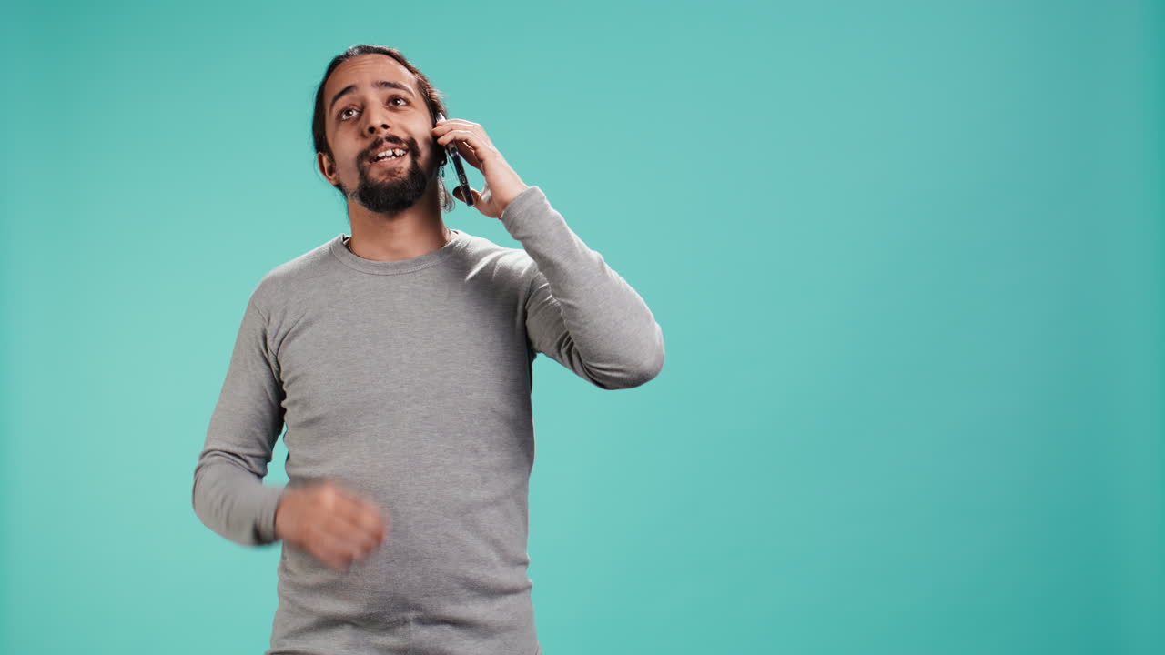 Premium stock video - Joyous man catching up with friends in phone call ...