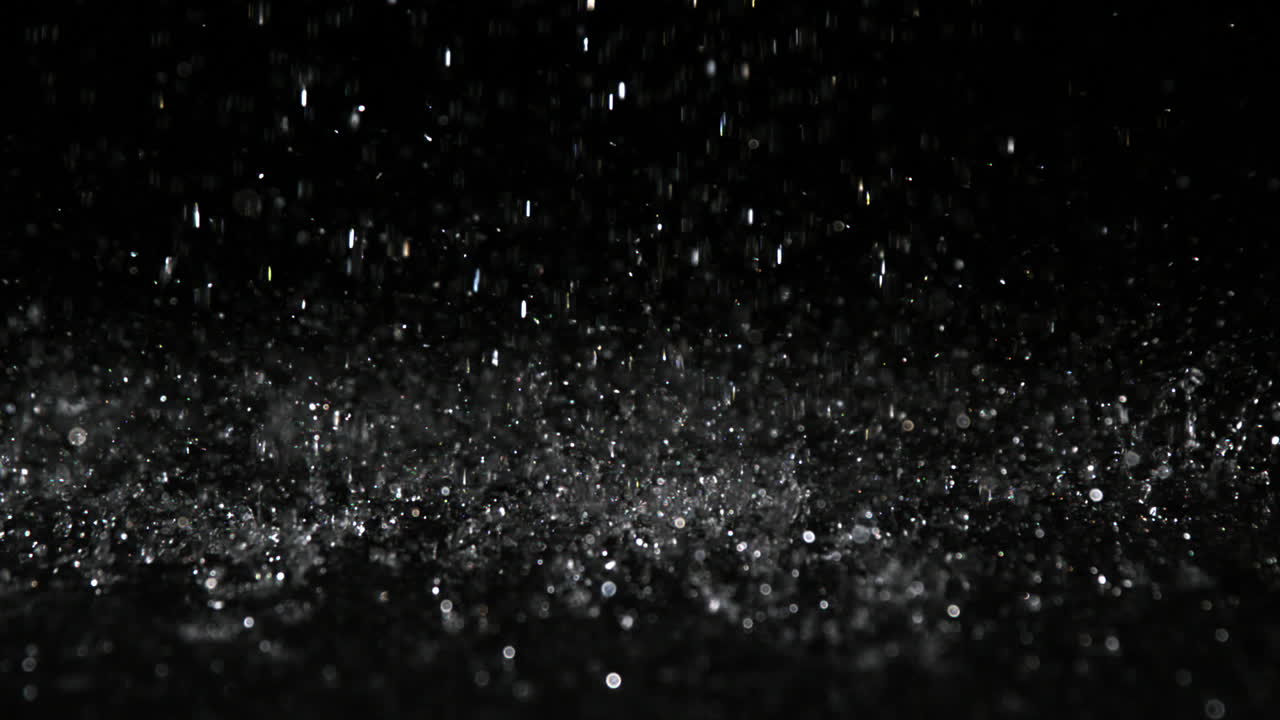 Premium stock video - Rain falling on black surface