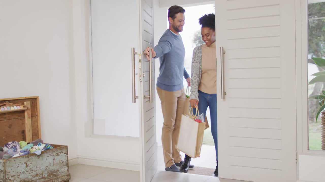 Premium stock video - Video of happy diverse couple walking into house ...