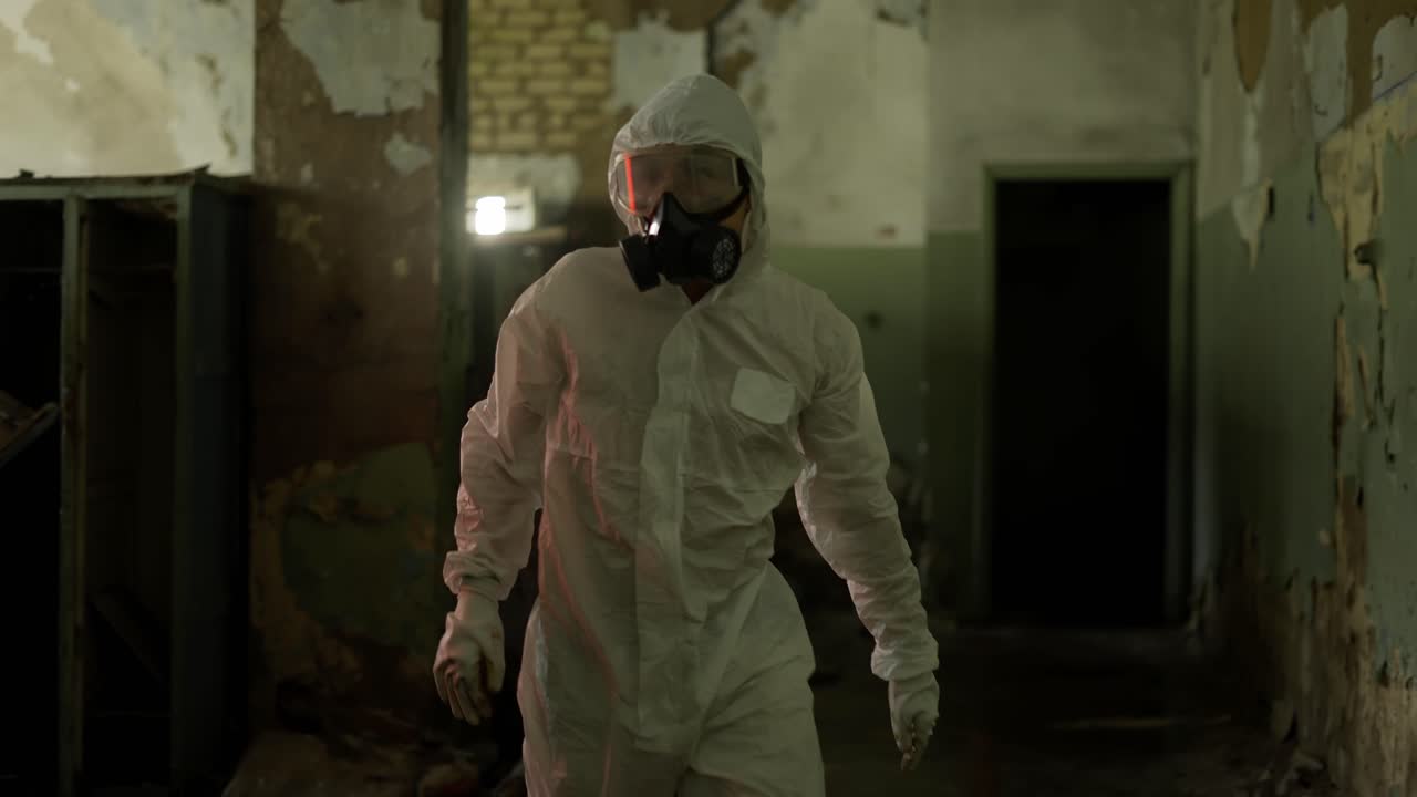 Premium stock video - Worker in protective suit inside the ruined ...