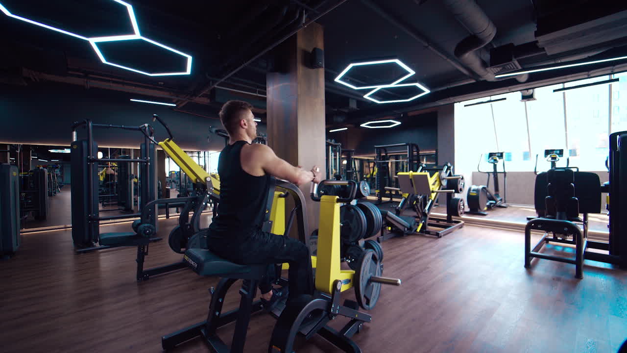 Bodybuilder man working out alone. Good looking athletic guy exercises ...
