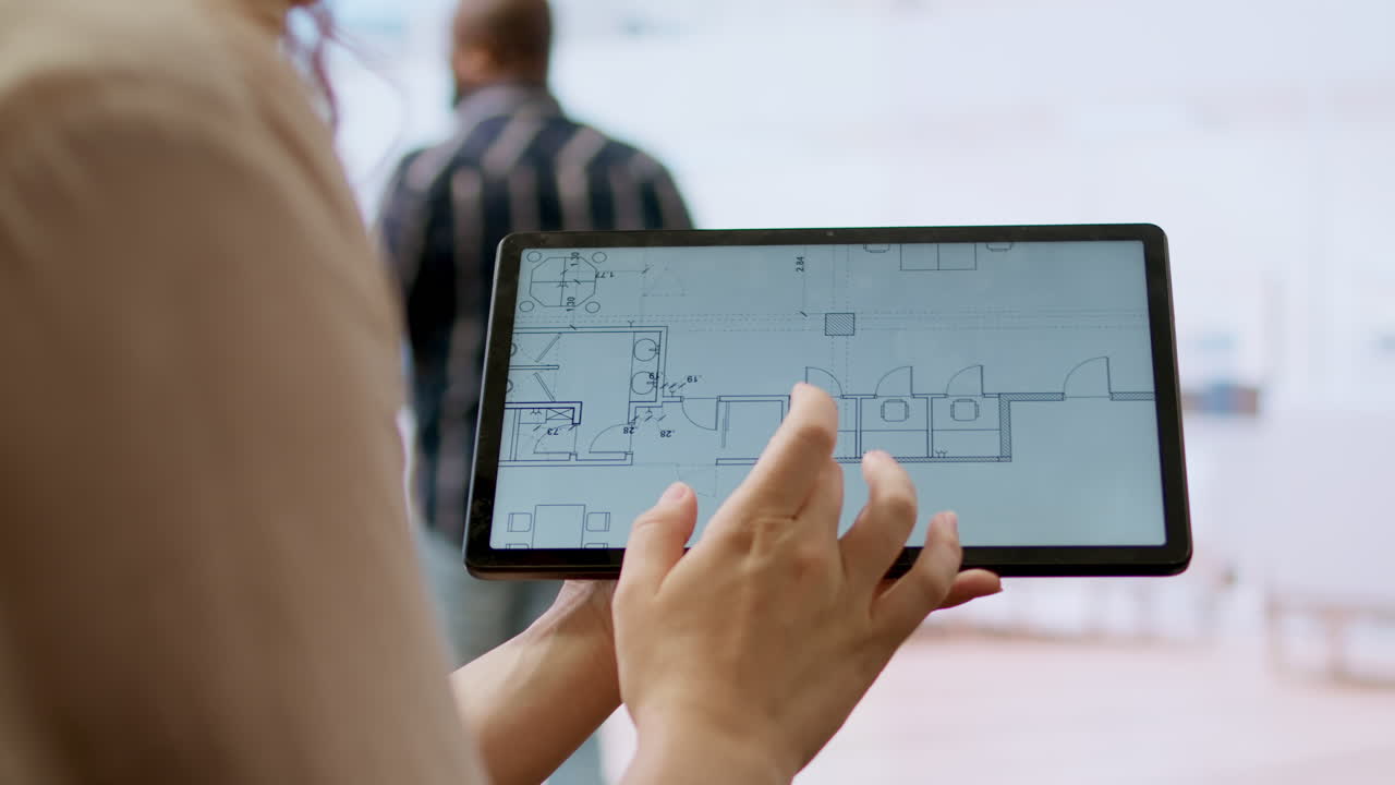 Real estate agent evaluating blueprints and discussing the architectural layout Premium Stock ...