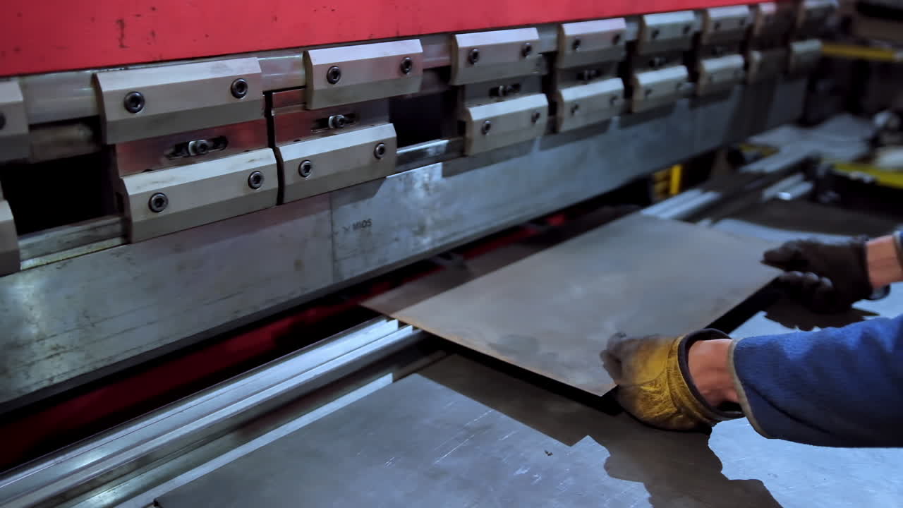 Sheet metal bending in factory. Metal sheet in workshop during ...