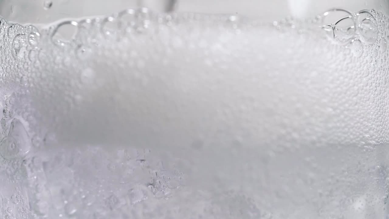 Pouring Soda Onto Ice Cubes In Glass Macro Filling Up With Carbonation Slow Motion Bubbles ...