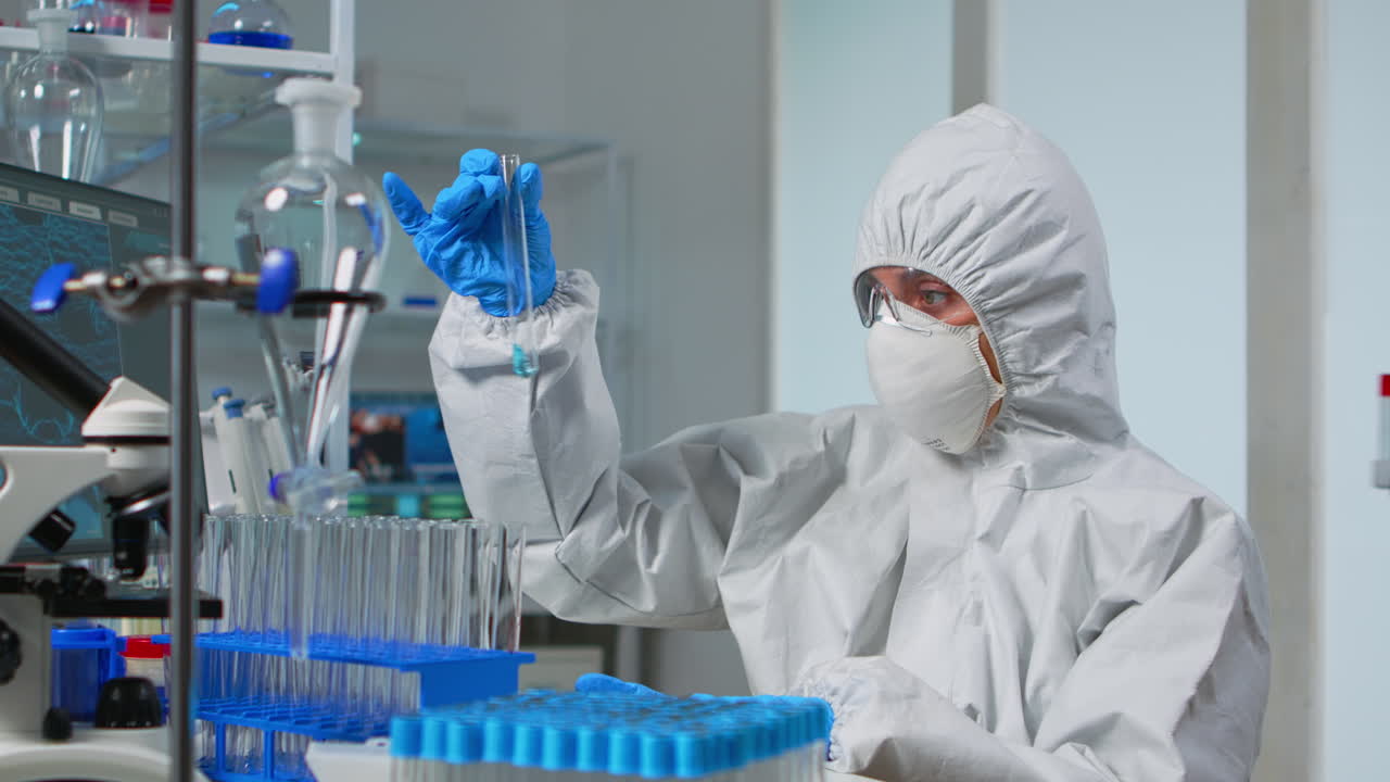 Premium stock video - Technician in ppe suit doing experiment checking ...