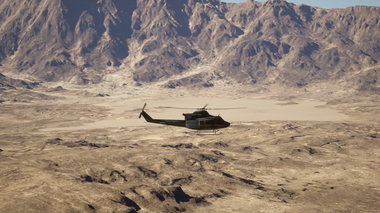 A helicopter flying over a desert landscape with mountains in the ...