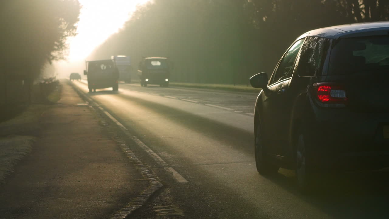 Premium stock video - Early morning traffic driving along road