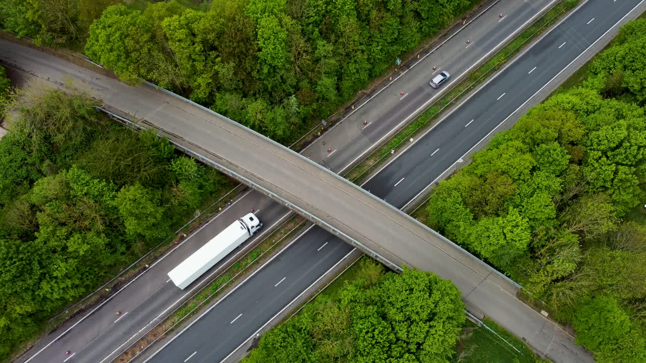 Premium stock video - Aerial view of cars and lorries passing under a ...