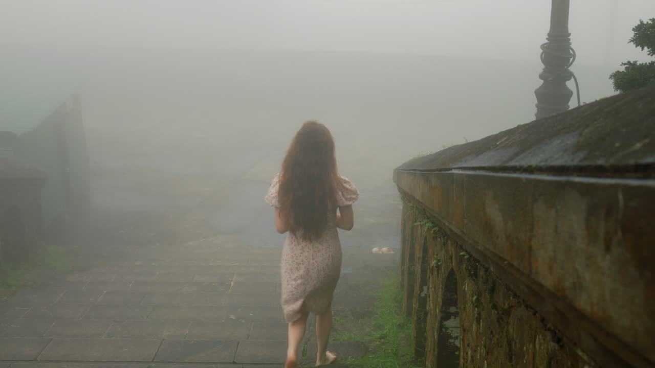 Young widow well dressed walking alone on to cemetery path with blue ...
