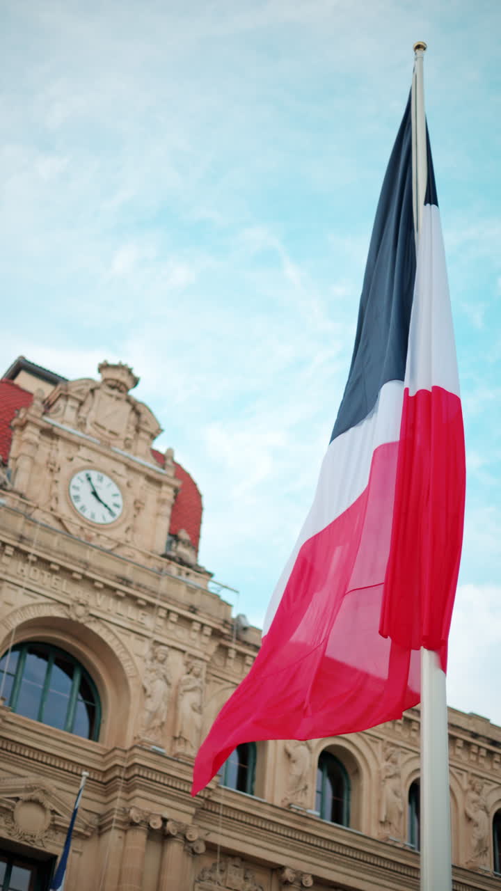 French flag waving in front of the Mairie de Cannes Town hall in Cannes ...