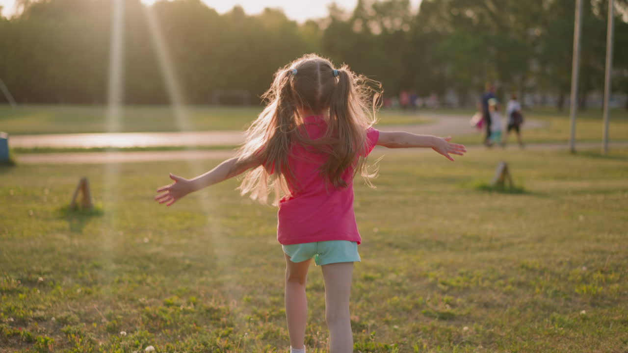 Premium stock video - Little girl with waving ponytails runs along lawn ...