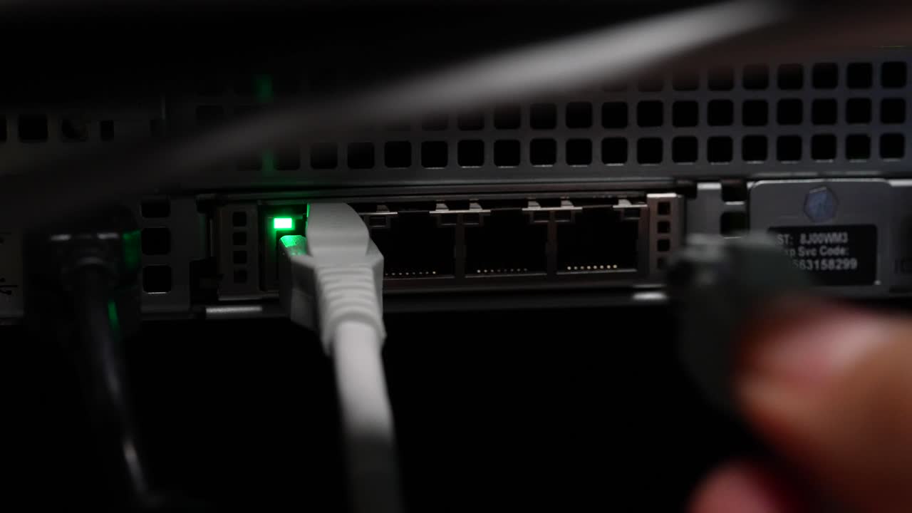 Premium stock video - Plugging four networking ethernet cables into network server switch by ...
