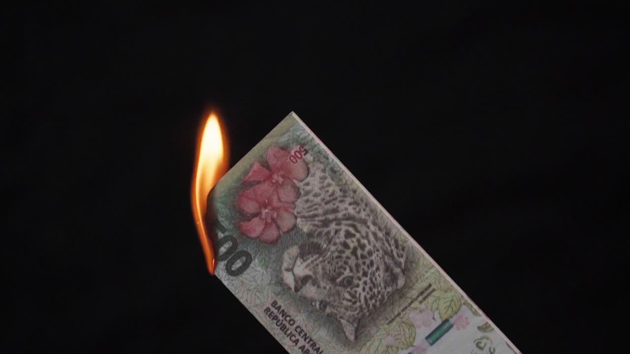Close-up of a burning argentinian 500 pesos bill illustrating the ...