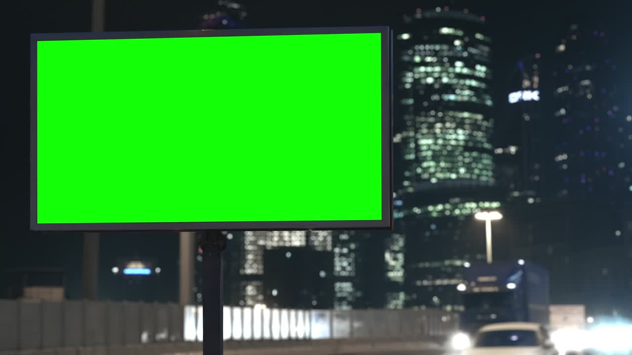 Green screen billboard on a busy highway with traffic, neon lights ...