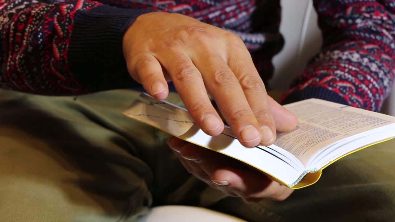 Premium stock video - Close up of hands flipping and reading the pages ...