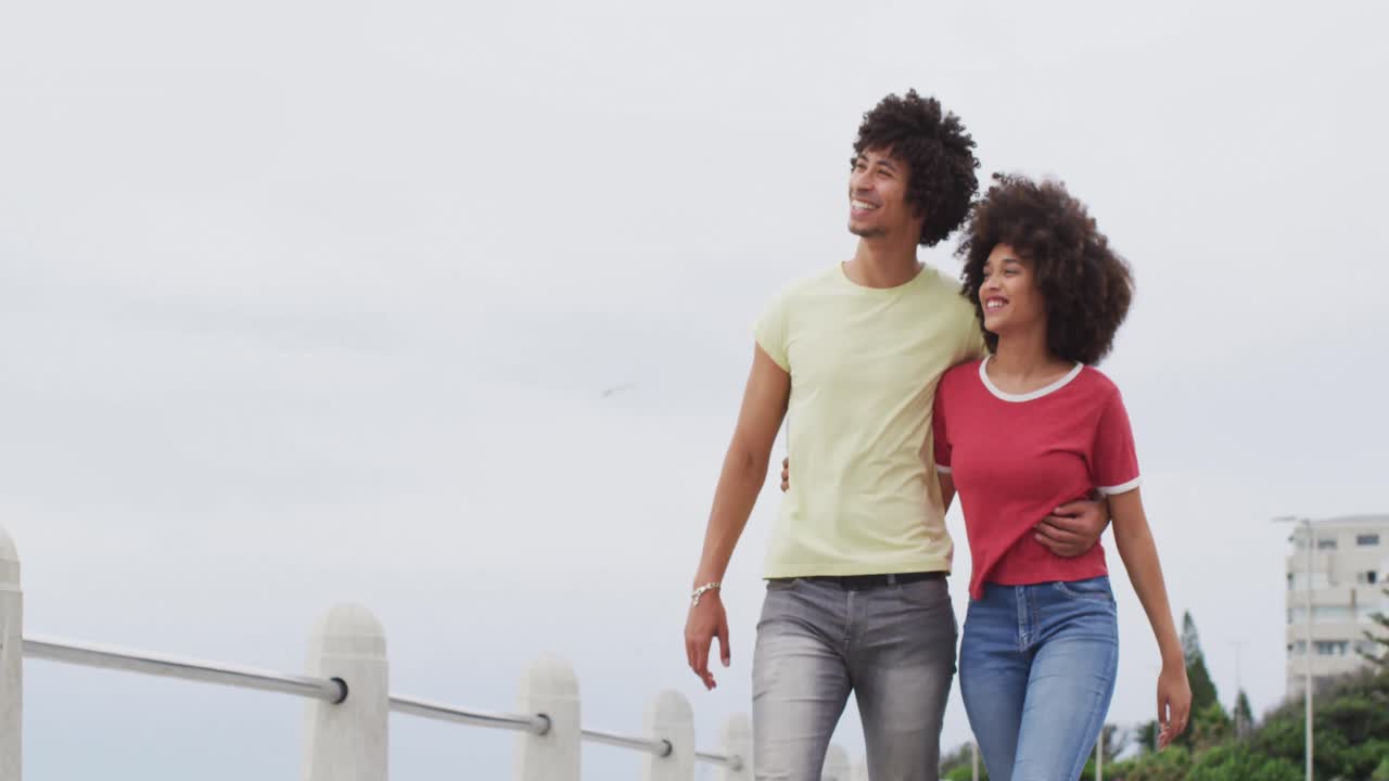 African american young couple hugging while walking together on the ...