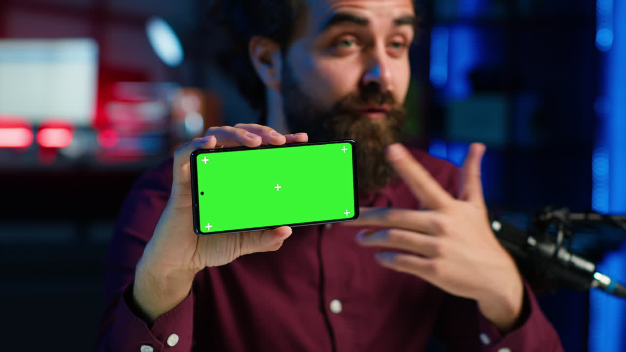 Premium stock video - Cheerful man assessing mockup smartphone performance