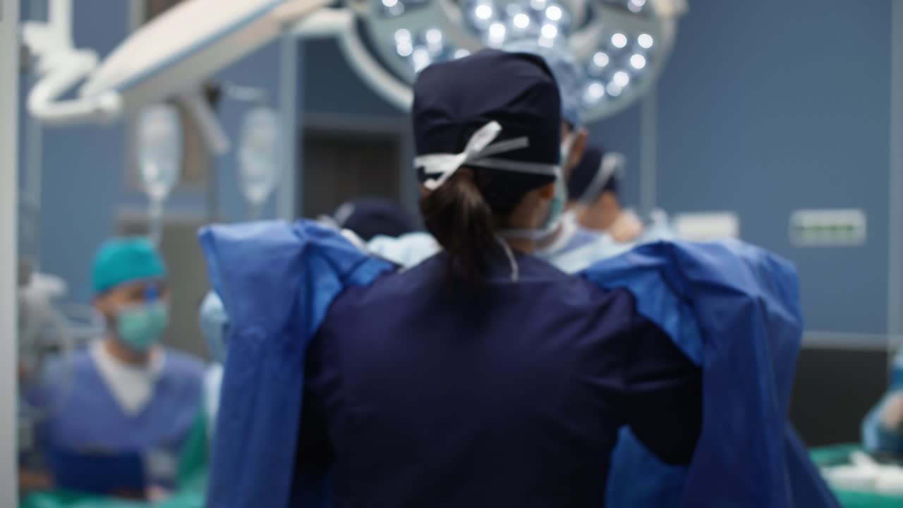 Premium stock video - Rear view of doctors before hard operation