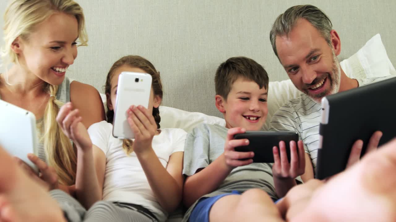 Family using electronic devices in bedroom at home 4k Premium Stock ...