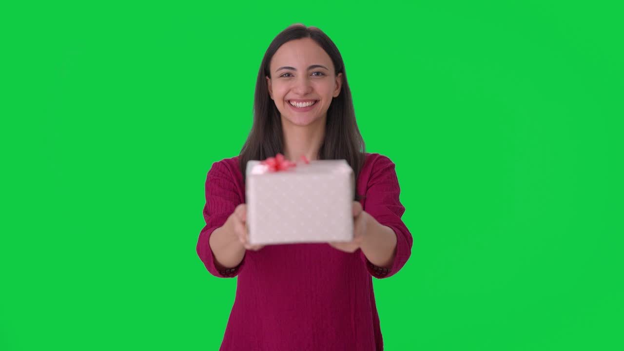 Premium stock video - Happy indian woman giving a gift green screen