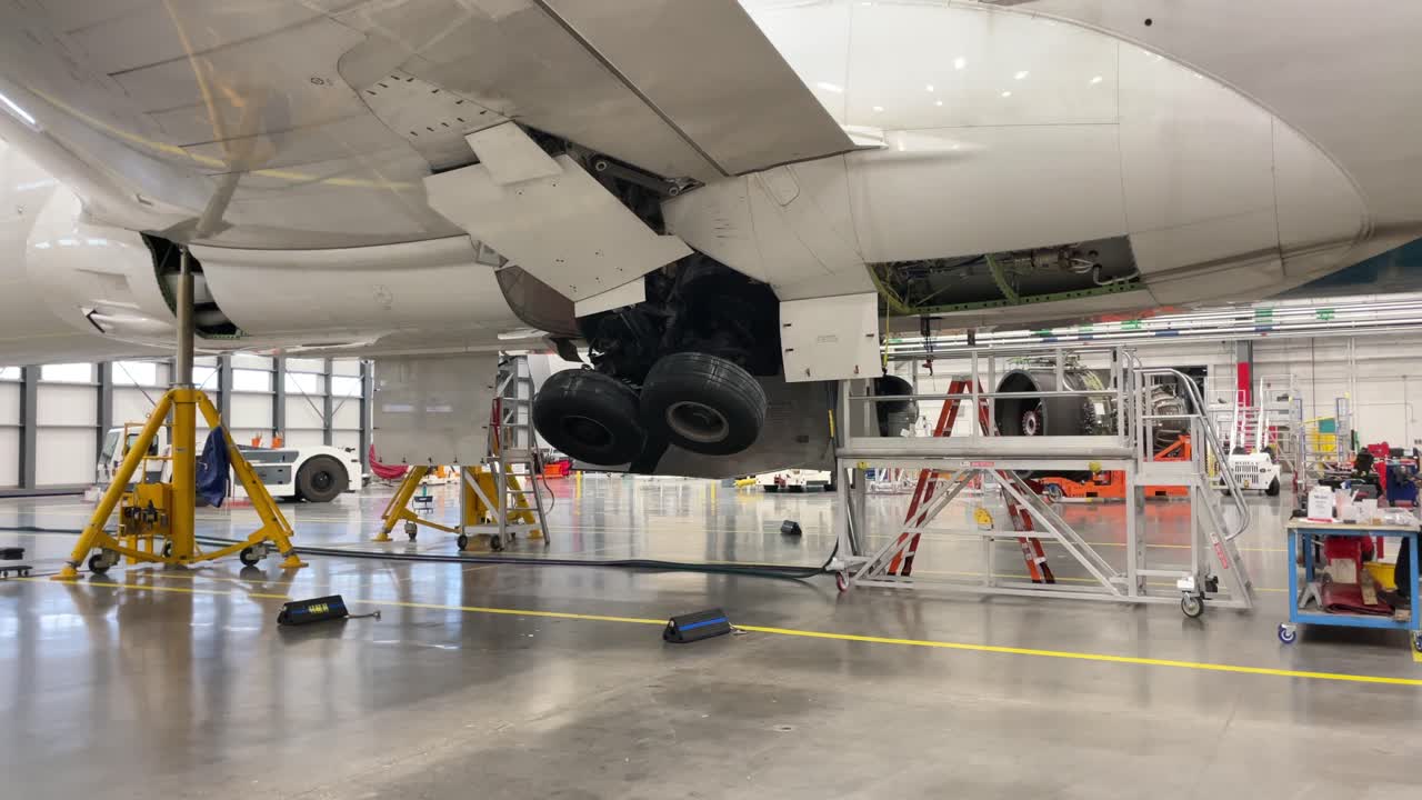 The landing gear of a large aircraft extend and retract into the ...