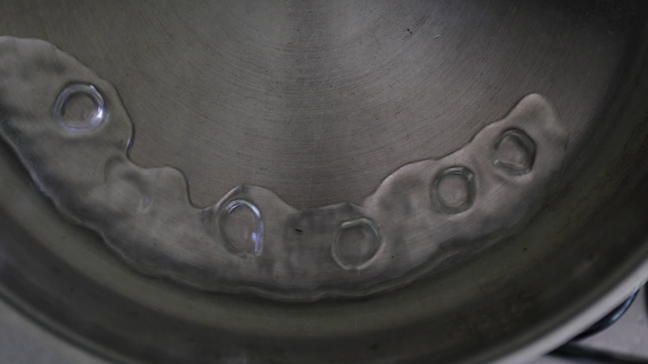 slow-motion view capturing the moment water splashes into a hot ...