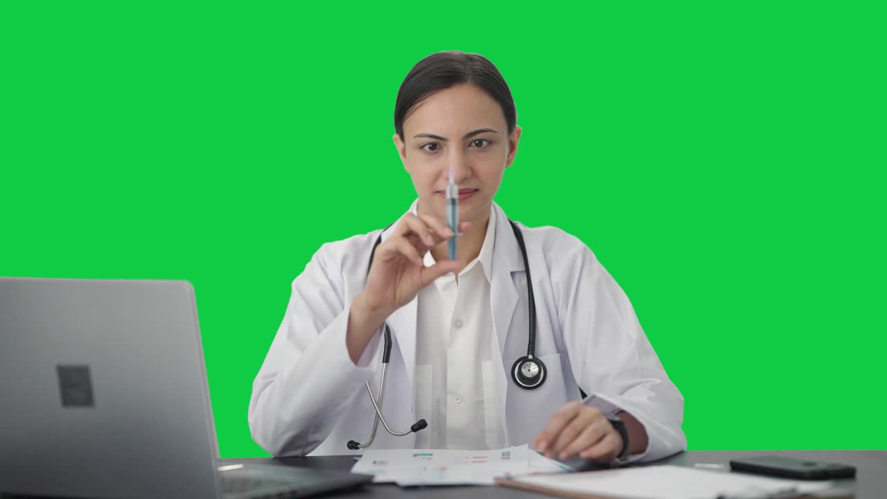 Premium stock video - Indian female doctor filling injection green screen