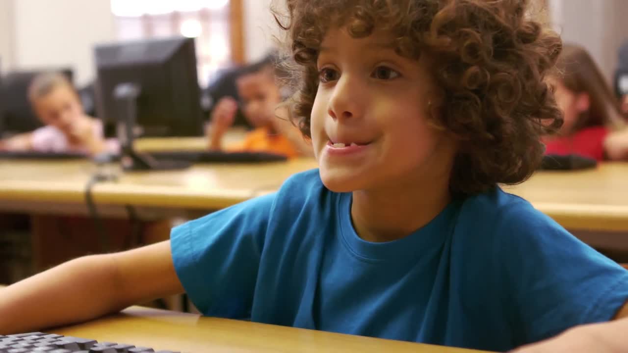 Premium stock video - Little boy using computer in classroom in school