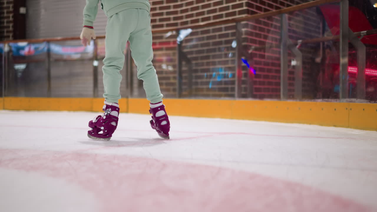 Close-up of someone skating in purple ice skates on an ice rink ...