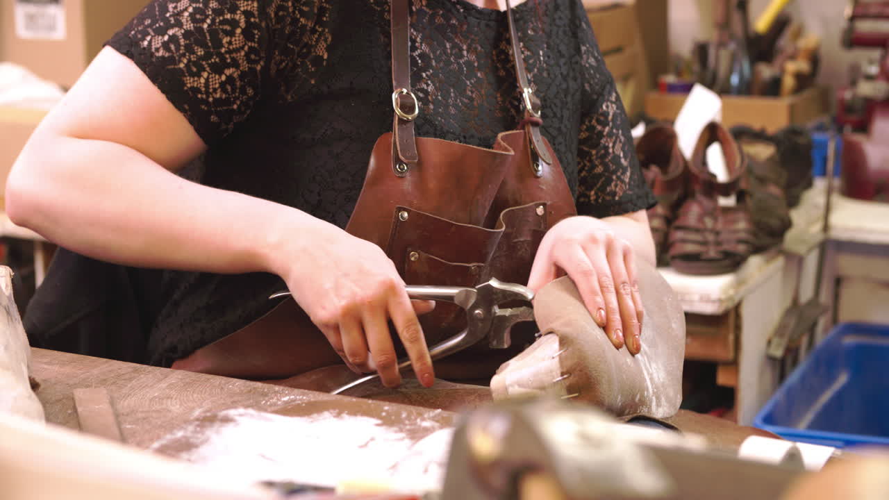 Premium stock video - Bespoke shoemaker pinning leather together to ...