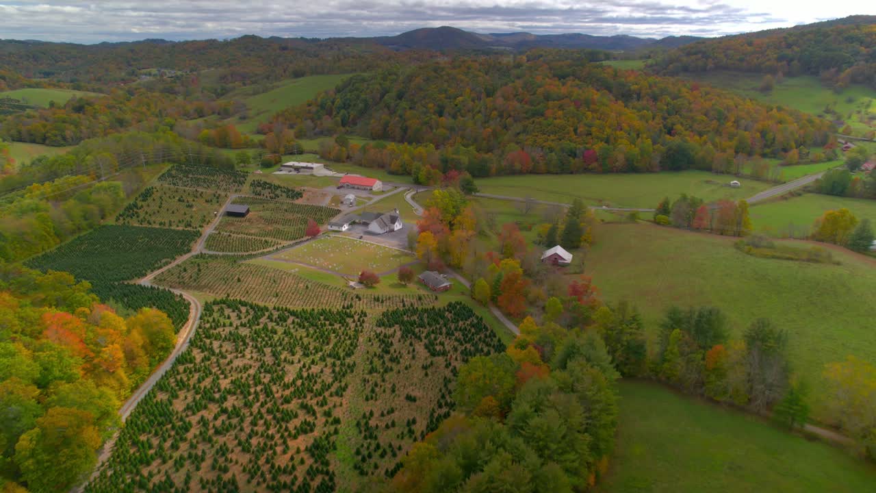 Drone glides over farm land and a country home in the mountain region ...