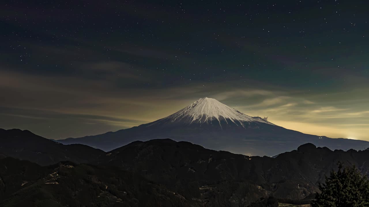 A majestic nighttime landscape featuring Japan’s iconic Mount Fuji, its ...